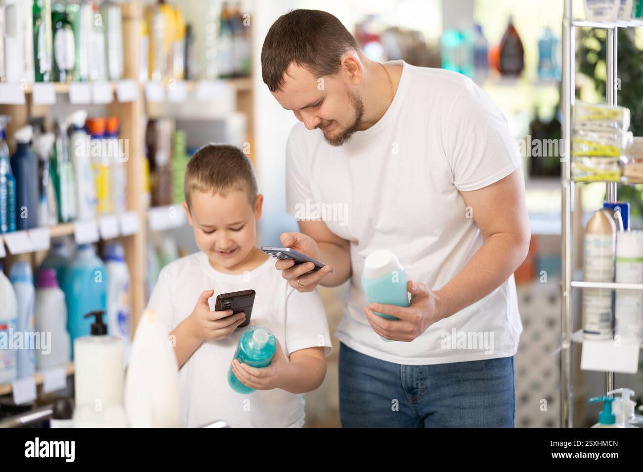 Dad and son scan barcode on packaging of shower gel Stock Photo - Alamy