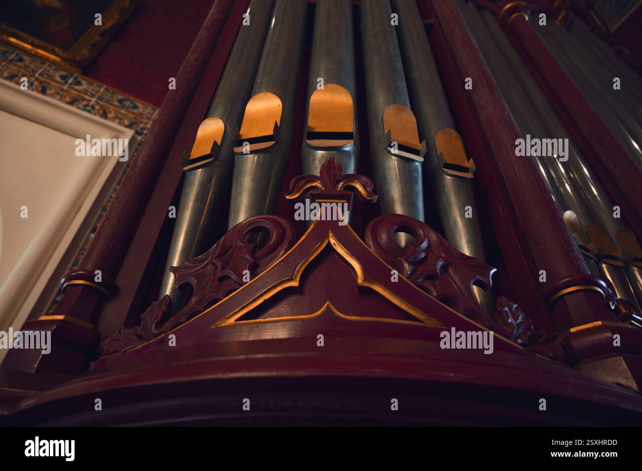 Close-up of a pipe organ with detailed wooden carvings and golden ...