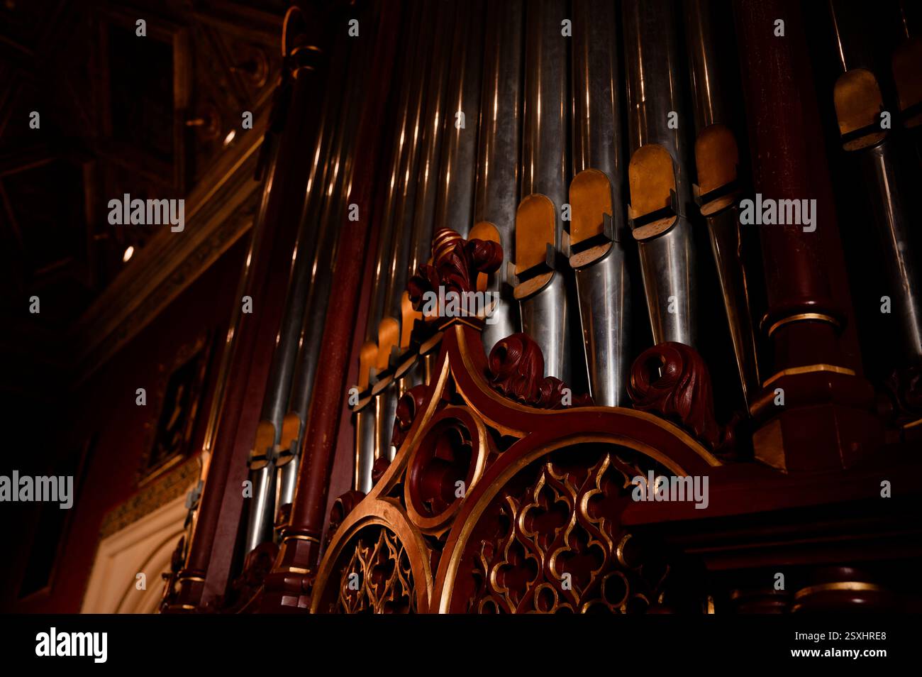 Ornate pipe organ with intricate wooden carvings and golden details ...