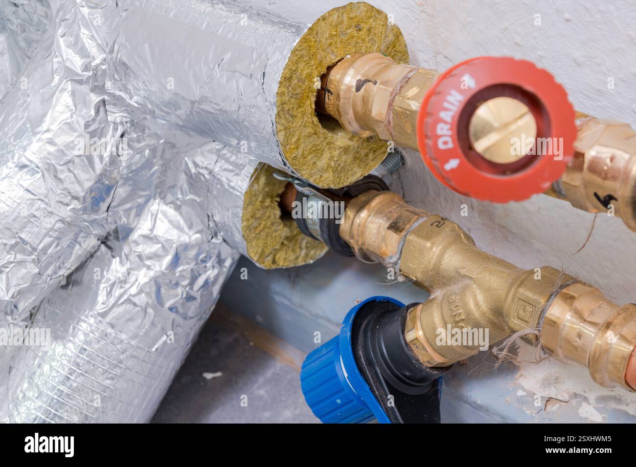 A close-up image of a heating pipe system with visible brass fittings ...
