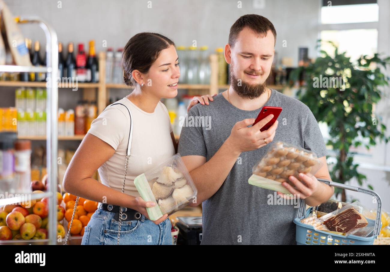 Couple man and woman scanning qr code for mushrooms Stock Photo - Alamy