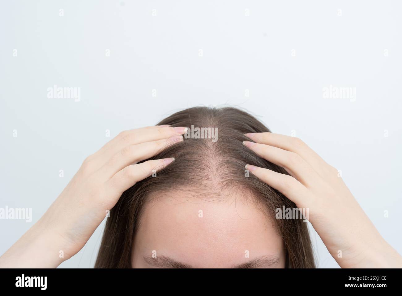 Close up view young woman massaging her scalp with hands for ...