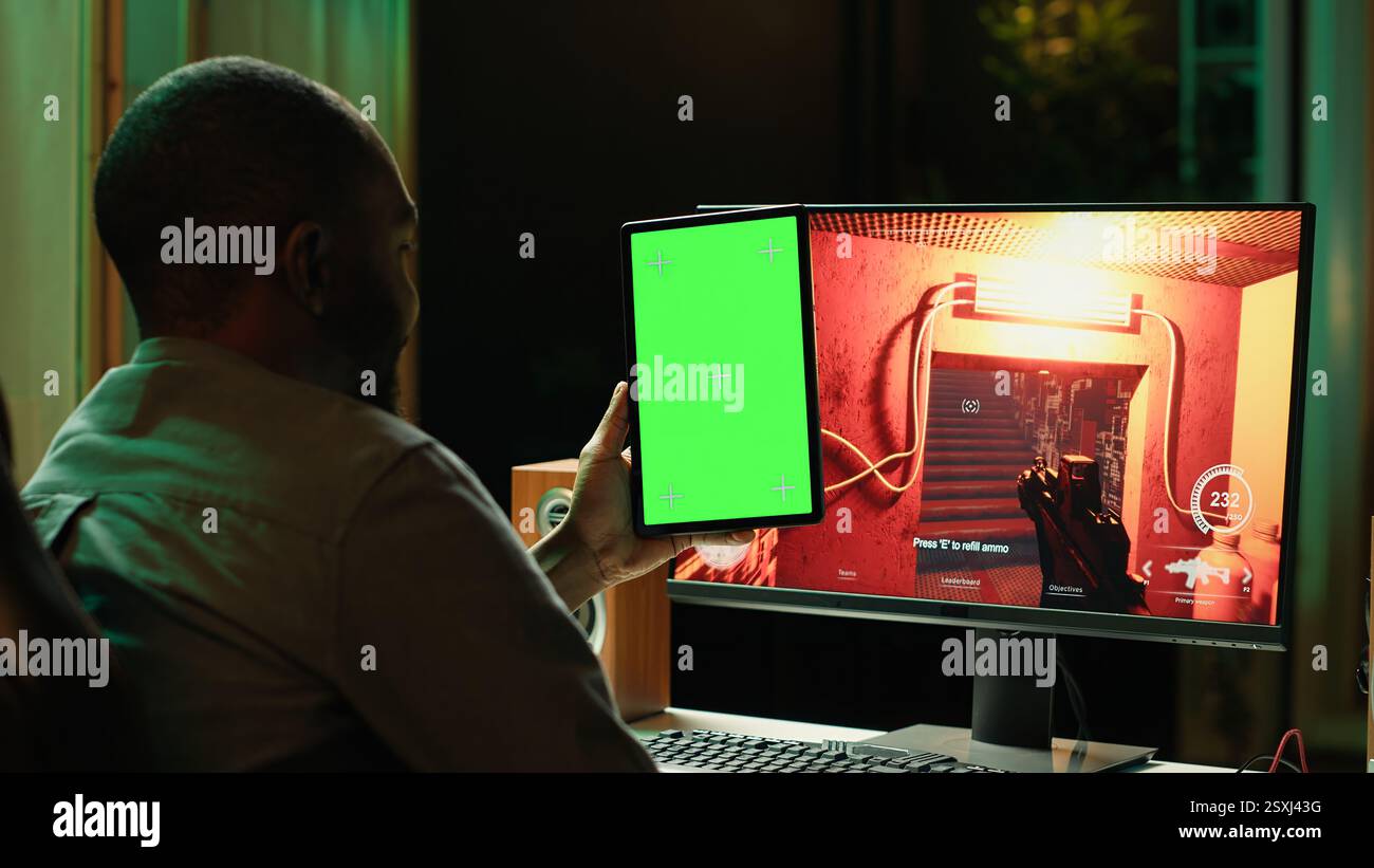 Man watching videos on green screen tablet while playing first person ...