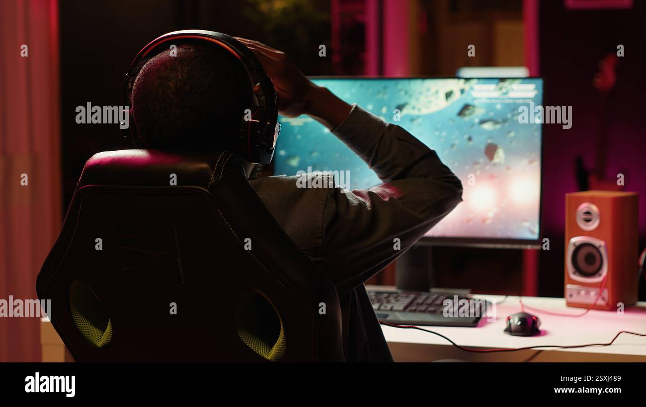 Pro gamer wearing headphones playing science fiction game. Content ...