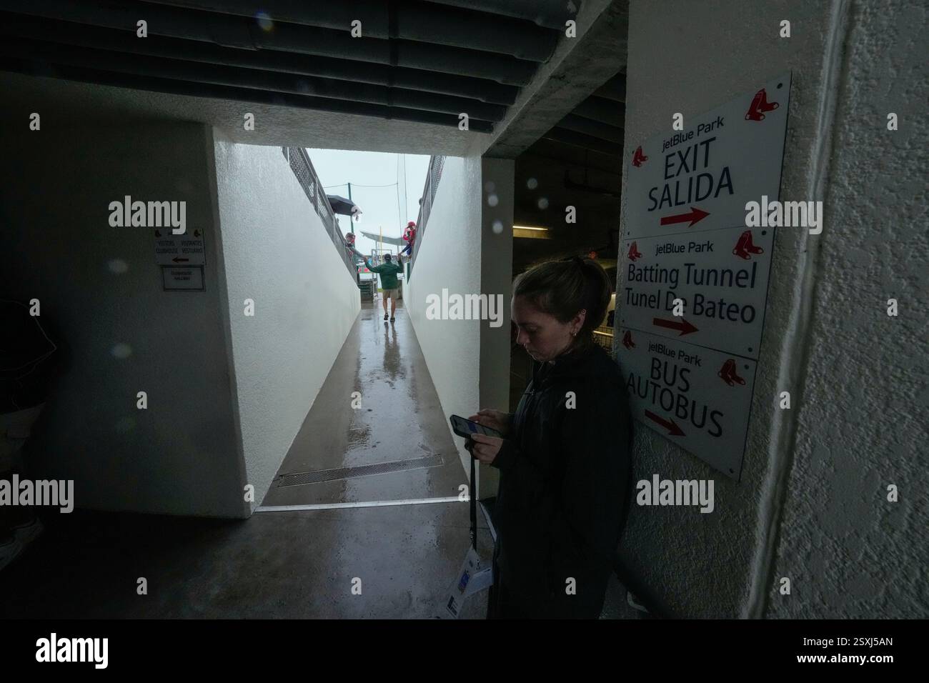 A JetBlue Park staffer greets fans in the rain before a postponed ...