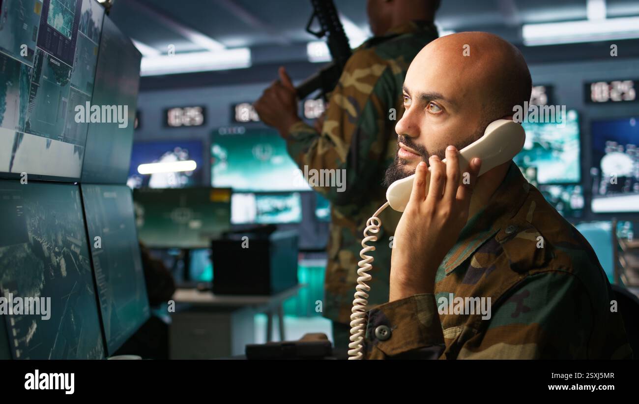 Military soldier in mission control center answering telephone call ...