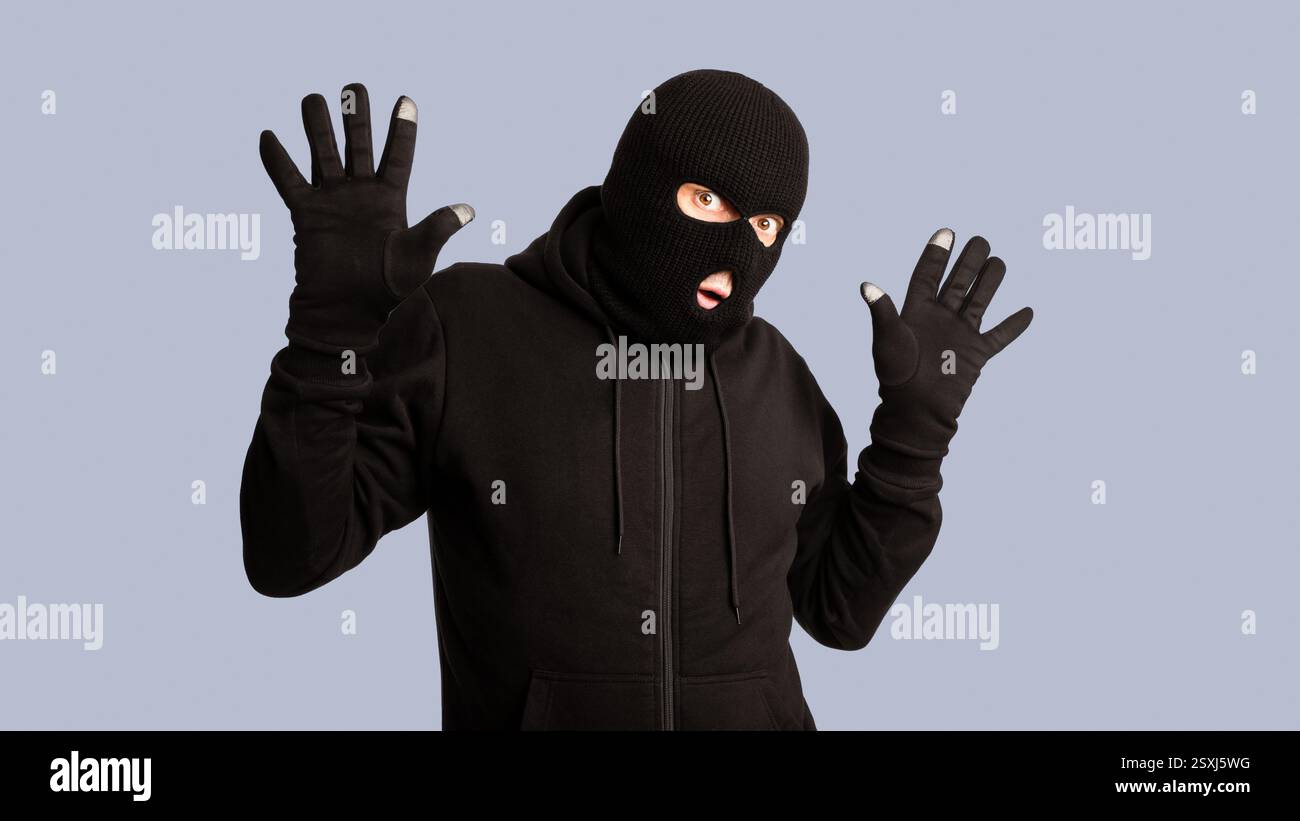 Arrested masked thief with raised arms isolated on white wall Stock ...