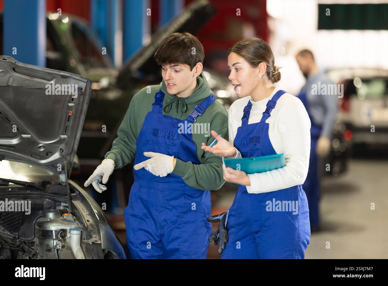 Mechanics talk about working on the car Stock Photo - Alamy
