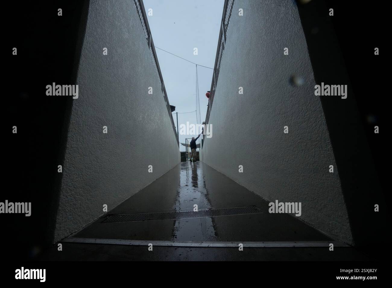 A JetBlue Park staffer greets fans in the rain before a postponed ...