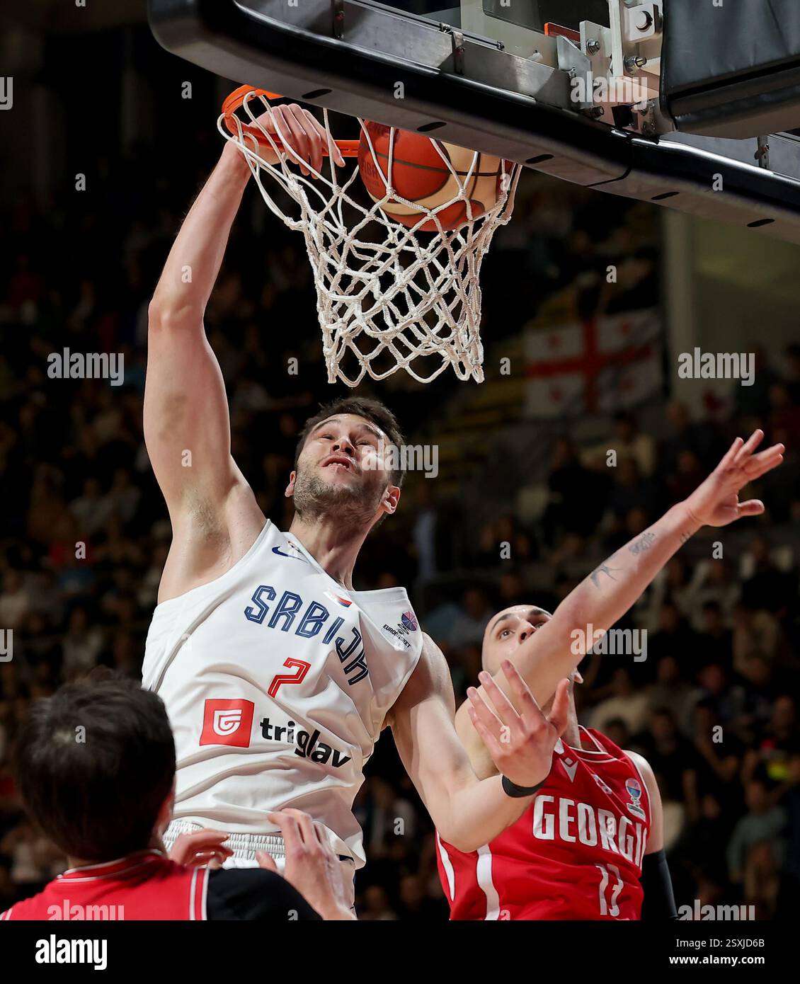 Belgrade. 24th Feb, 2025. Serbia's Mario Nakic (L) dunks past Georgia's ...