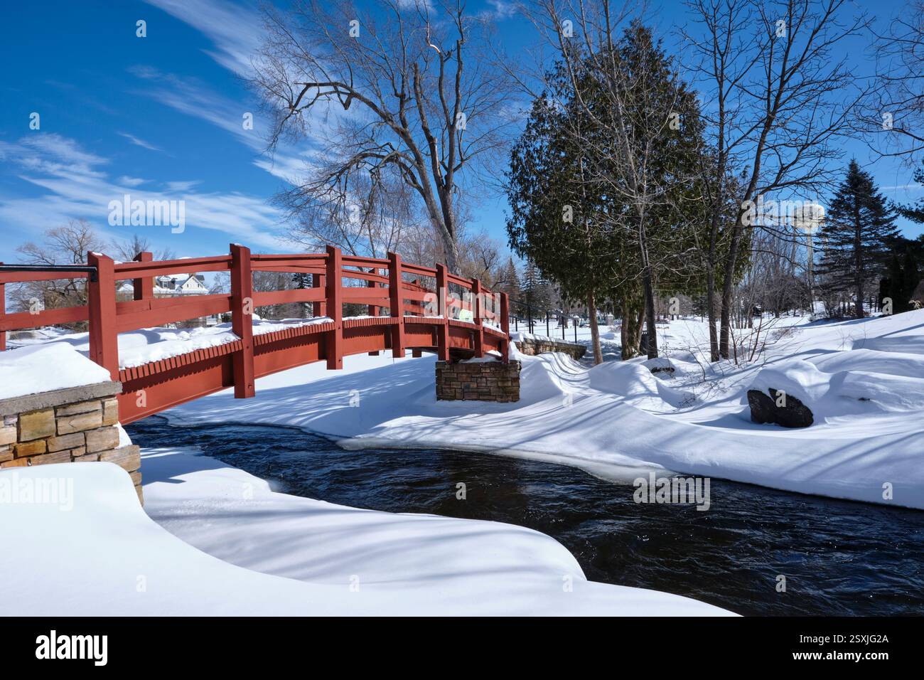 A winter scene of the red footbridge in Stewart Park, Perth, Ontario ...