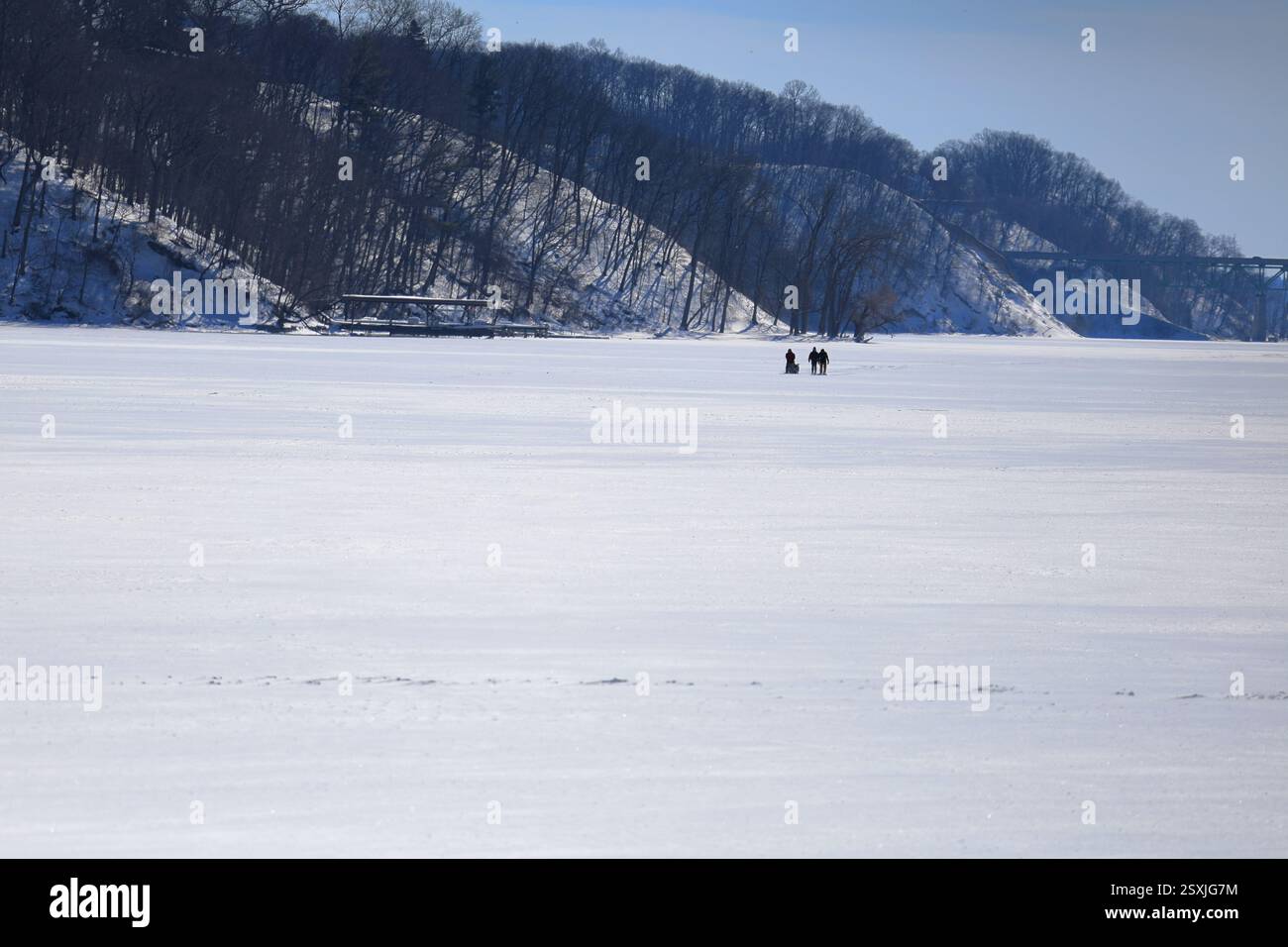 Three ice fishermen dragging their sled across the frozen lake Stock ...