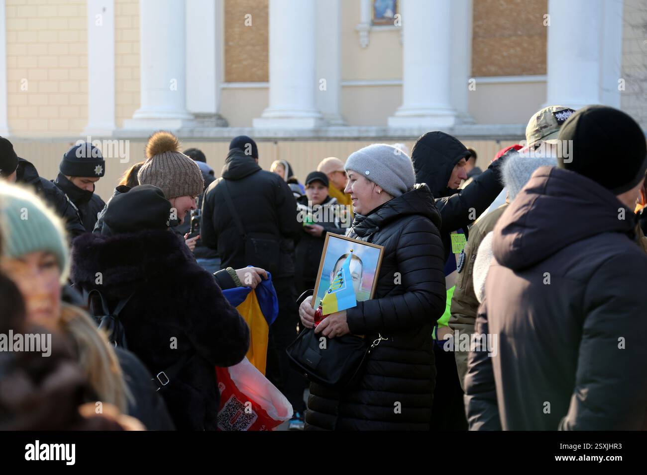 A participant in the commemoration procession holds a photo of the ...