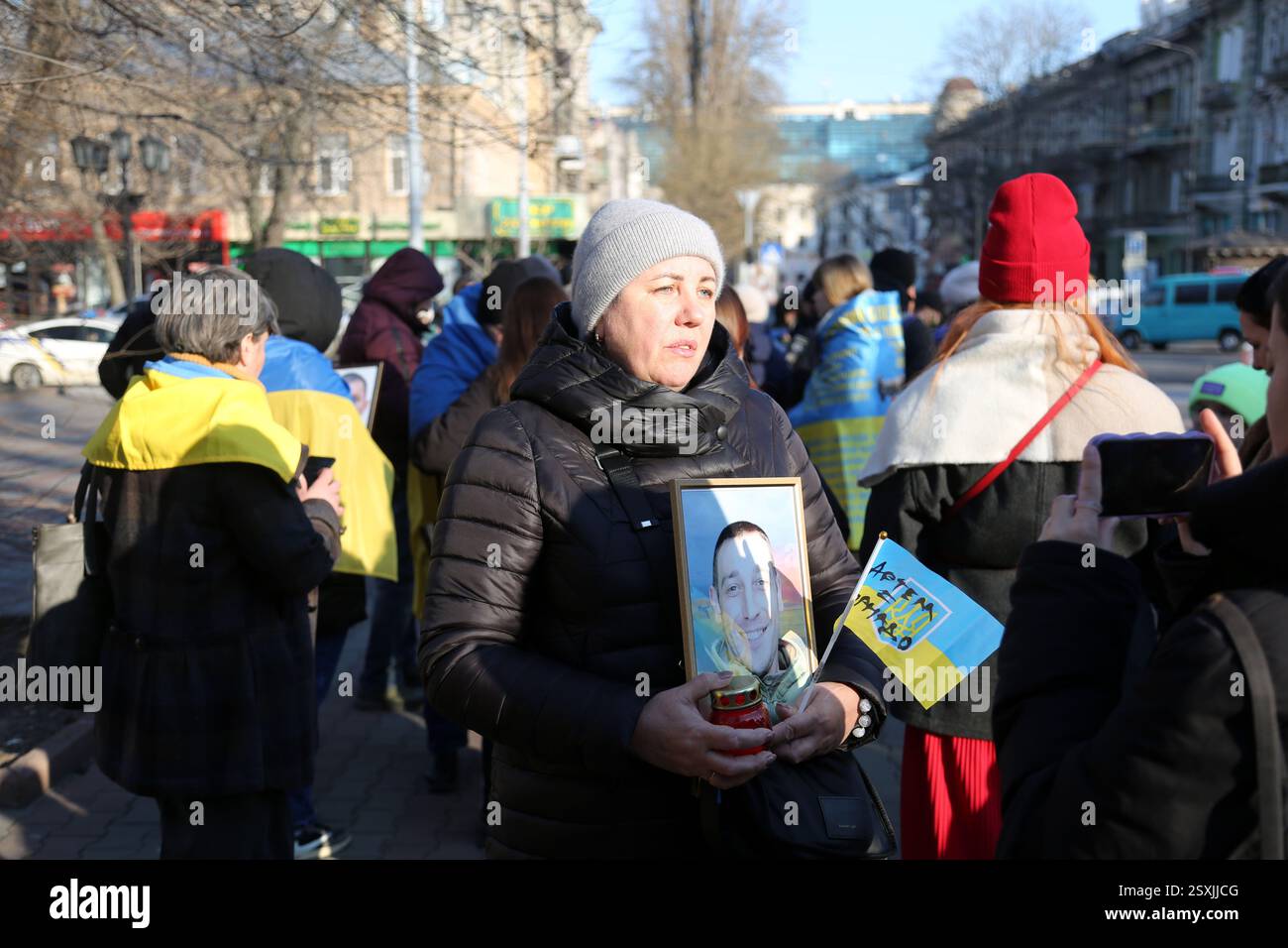 A participant in the commemoration procession holds a photo of the ...