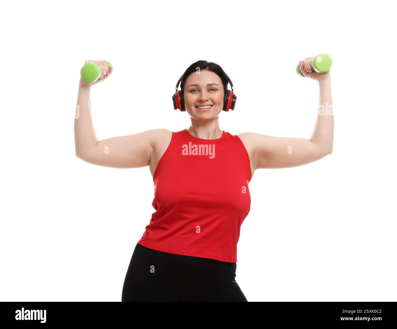 Plus size woman in gym clothes doing exercise with dumbbells on white ...