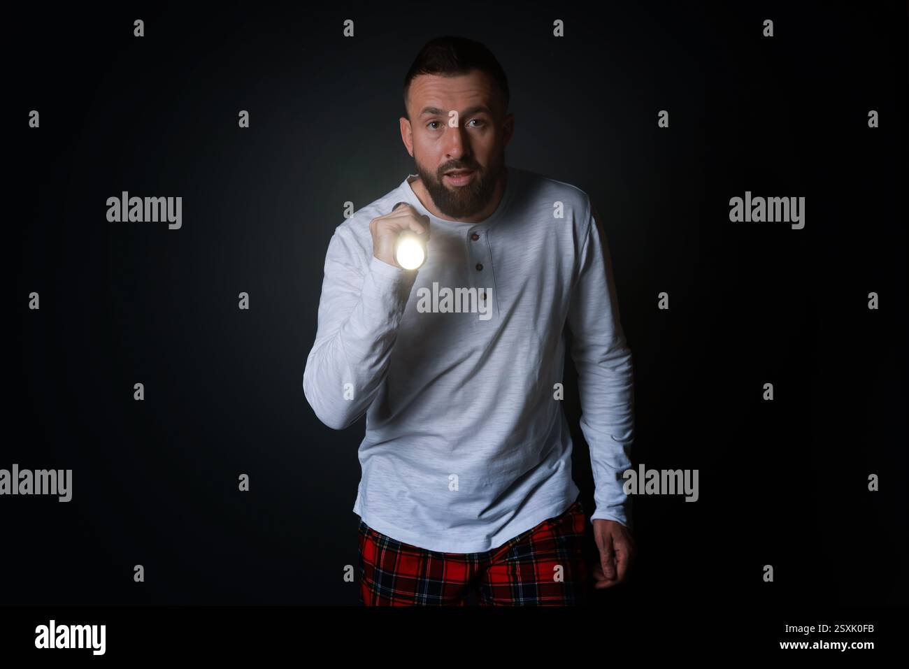 Fear of darkness. Scared man with flashlight on black background Stock ...