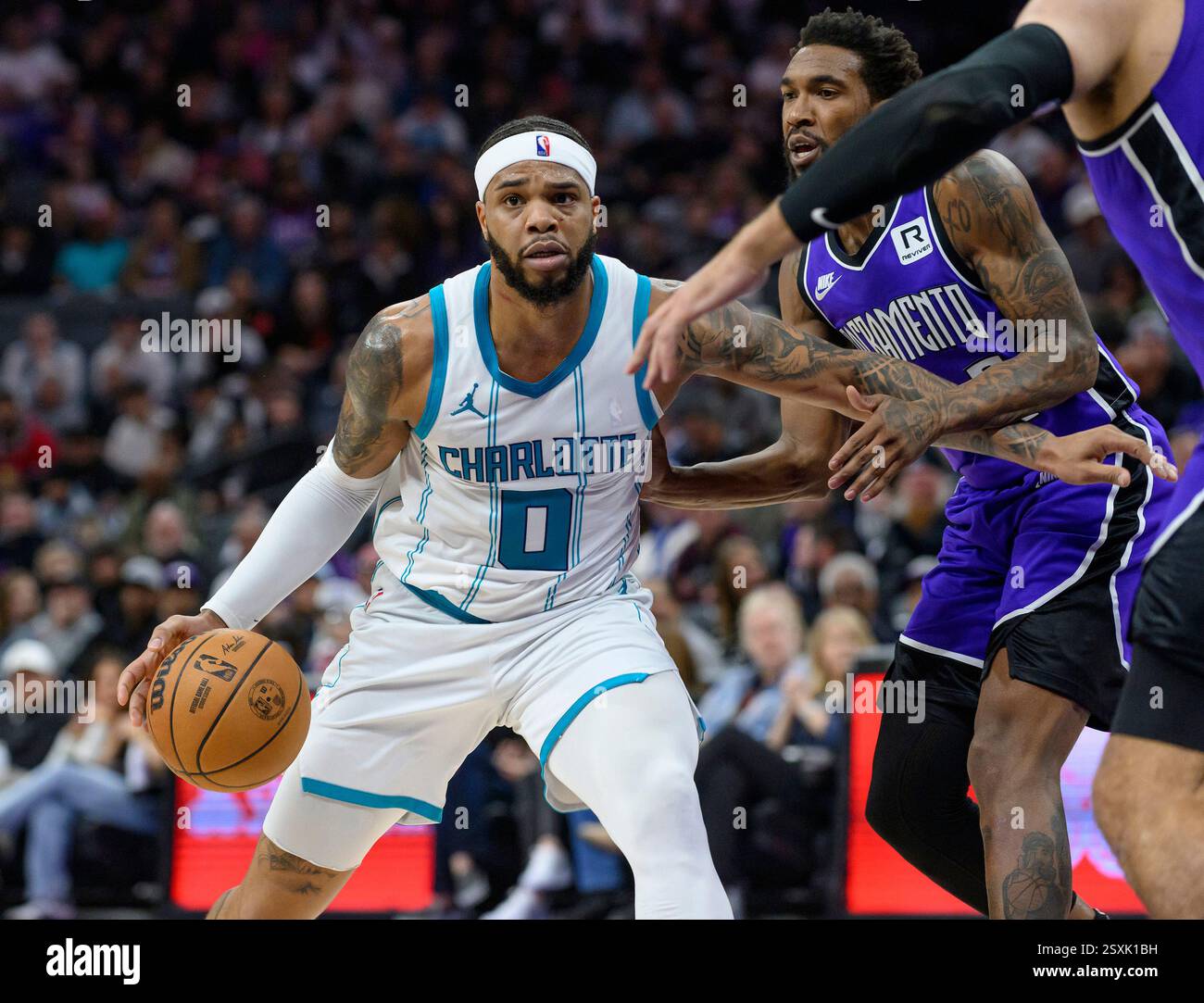 Charlotte Hornets forward Miles Bridges (0) is guarded by Sacramento Kings guard Malik Monk ...