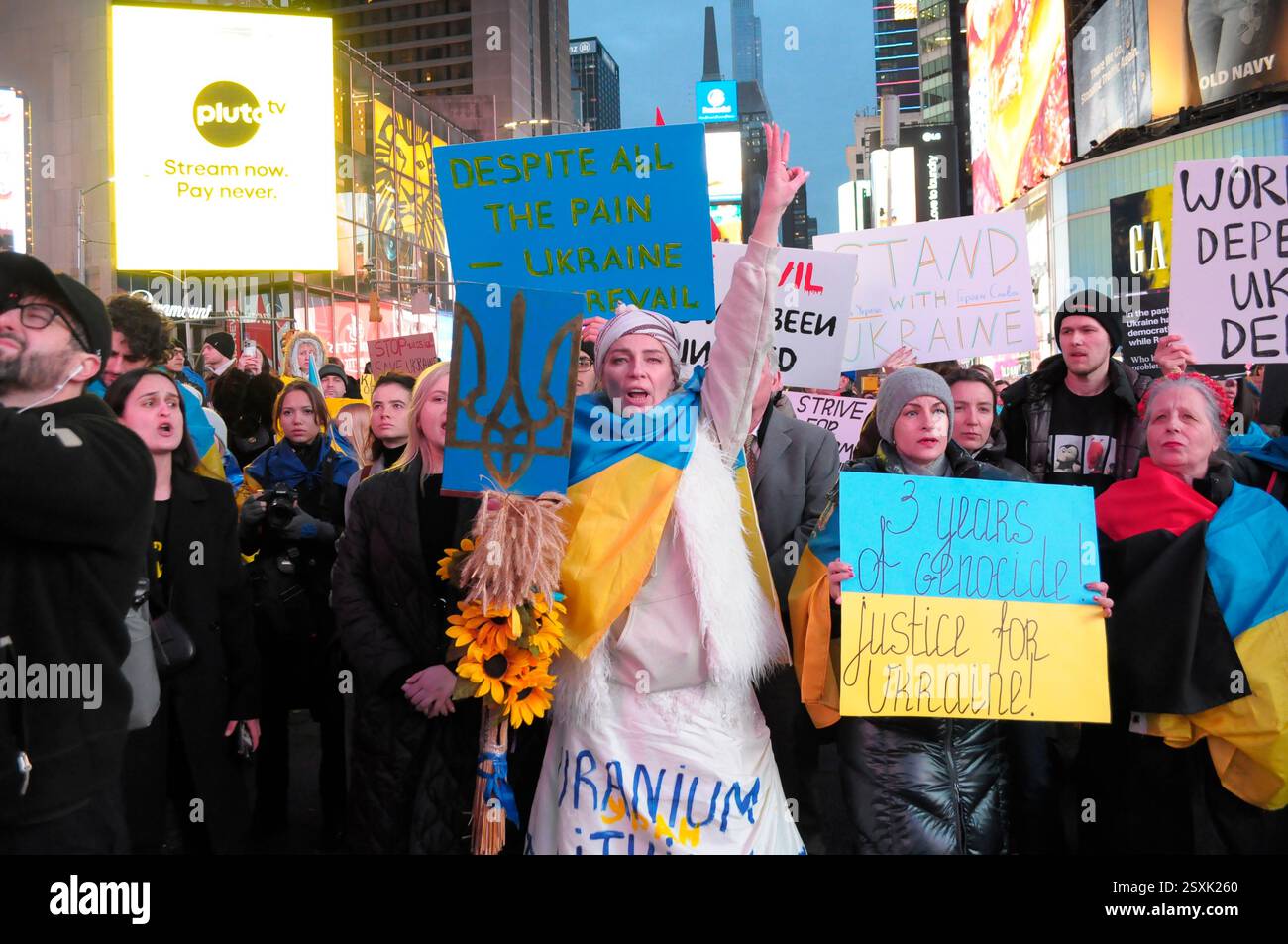 A pro-Ukraine demonstrator draped in the Ukrainian flag, holds up a ...