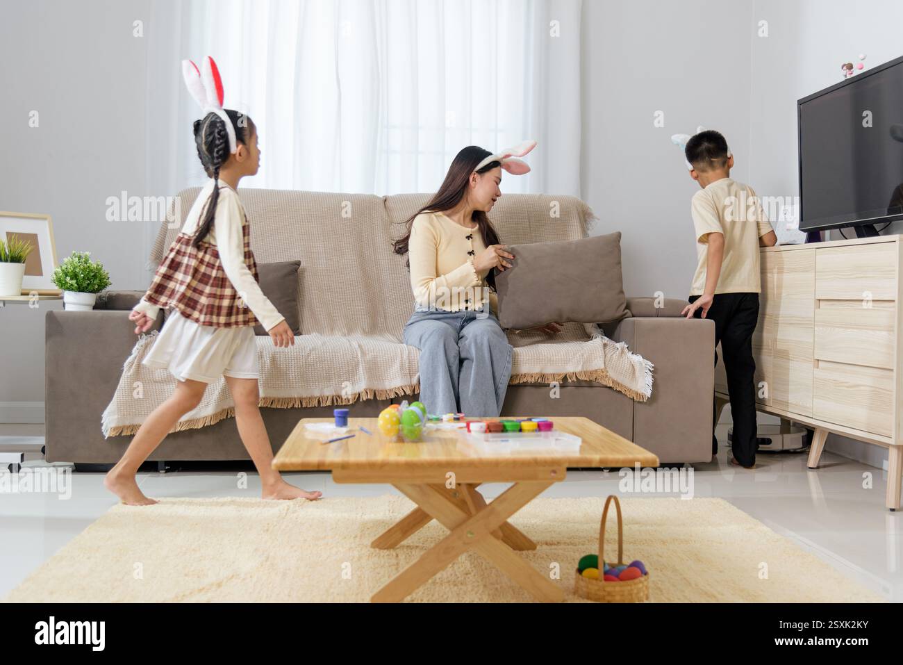 Easter celebration. A mother and children in bunny ears enjoy searching ...