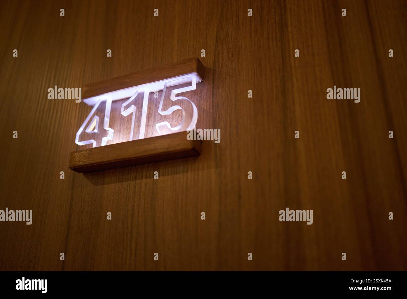 Glowing Hotel Room Number Sign on Wooden Door Stock Photo - Alamy