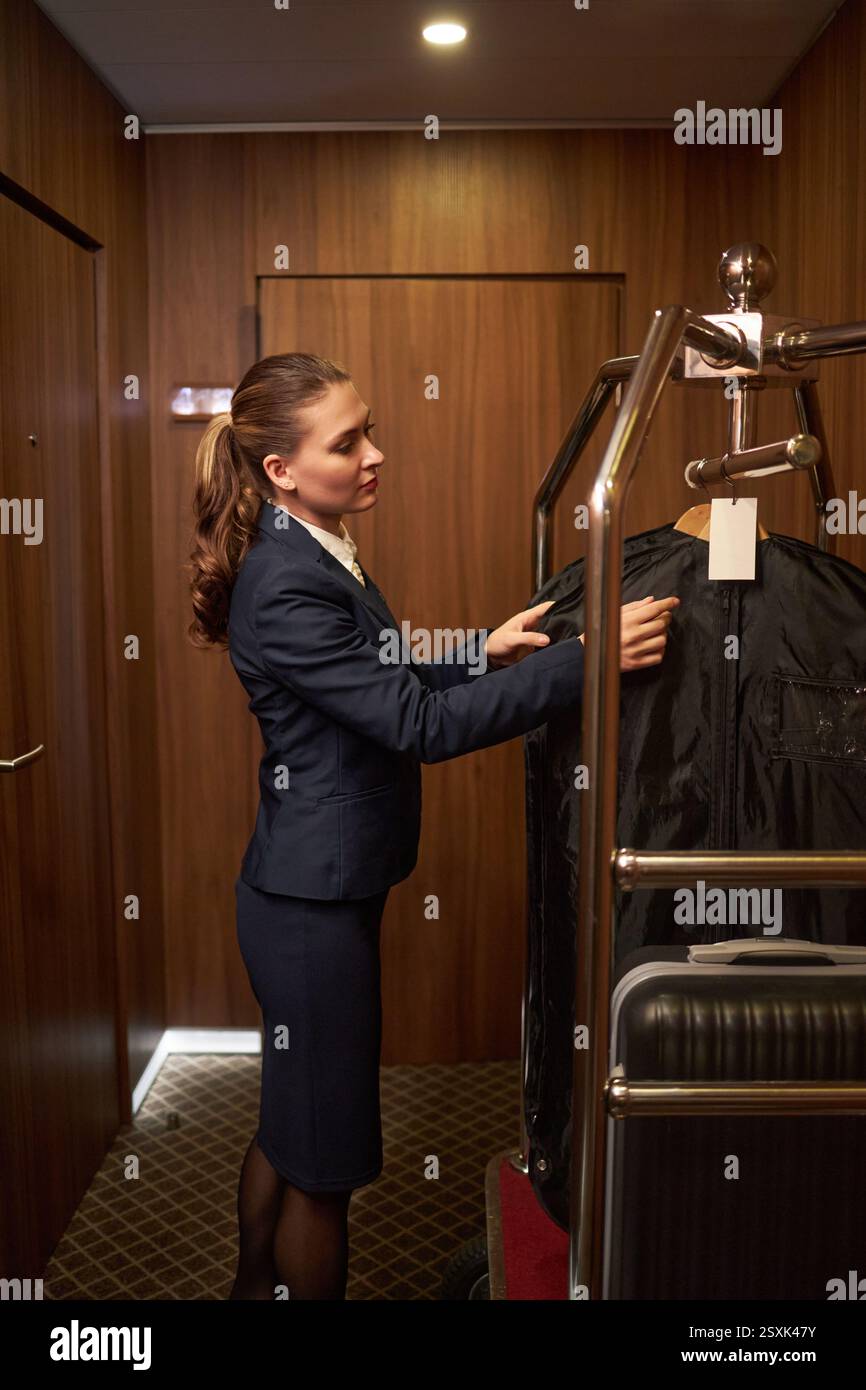 Hotel Staff Organizing Guest's Garments in Hallway Stock Photo - Alamy