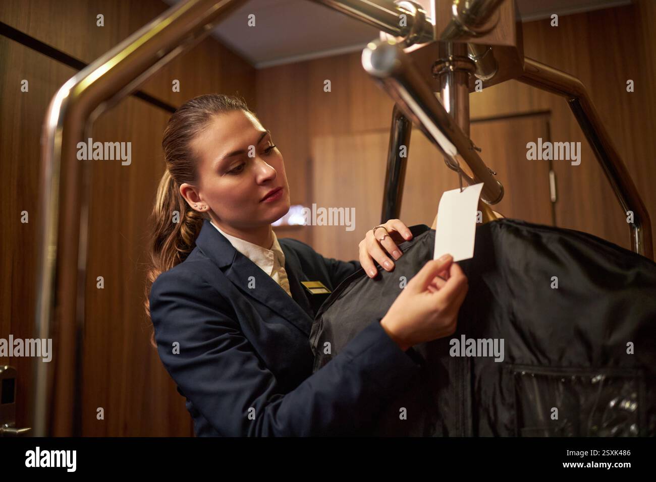 Businesswoman Checking Garment with Folded Note Stock Photo - Alamy