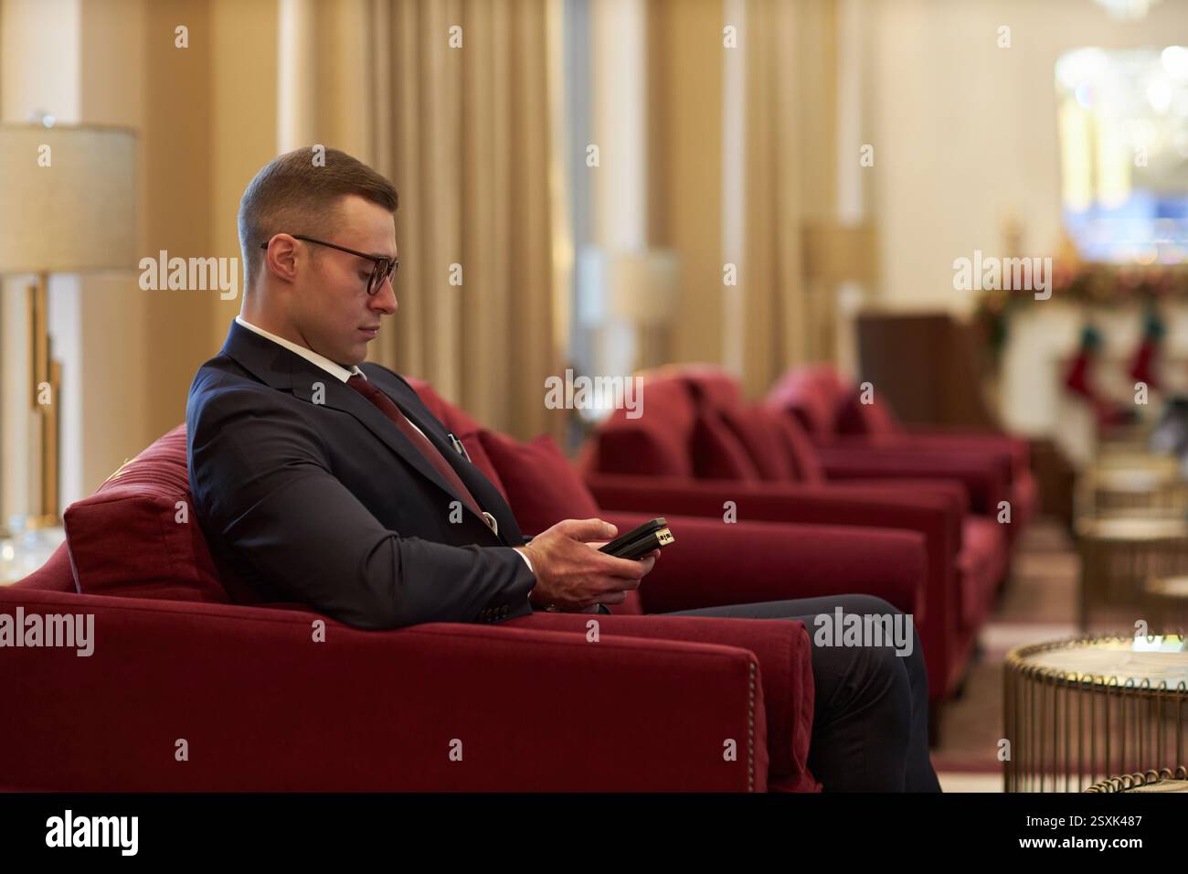 Man in Business Suit Sitting in Luxury Hotel Lobby Stock Photo - Alamy
