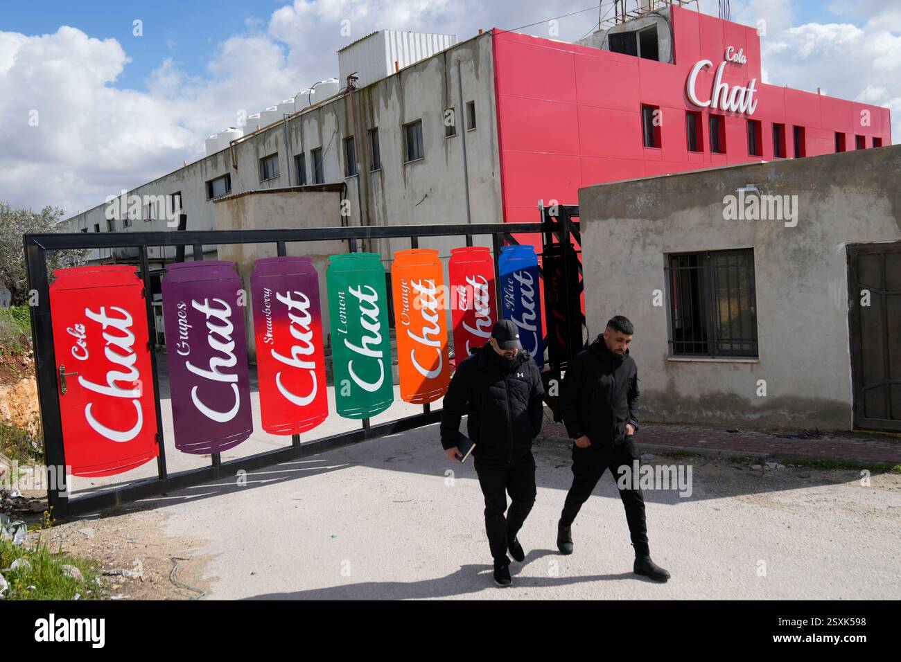 Employees walk out of the bottling plant of the Chat Cola Company in ...