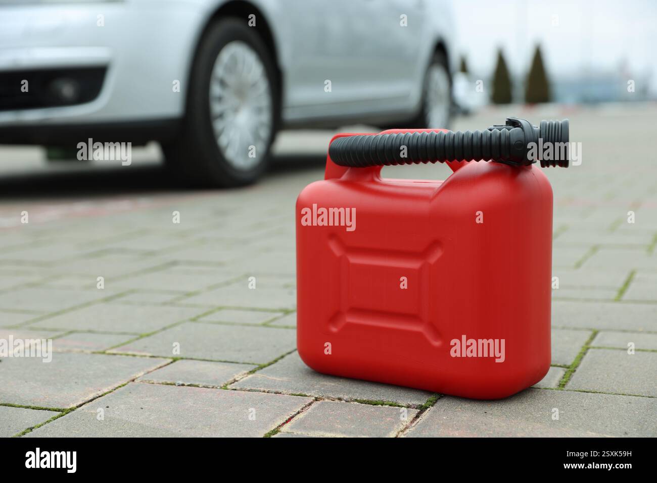 Red plastic canister with spout on pavement outdoors Stock Photo - Alamy