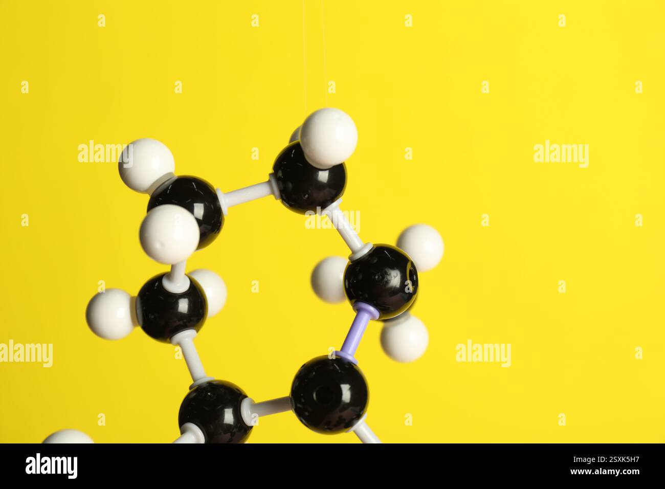 Molecule of retinol (vitamin A) on yellow background, closeup and space ...