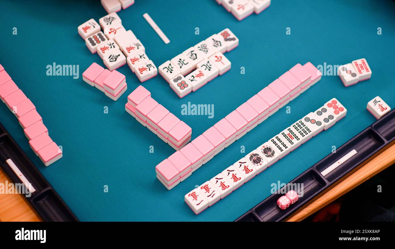 A mahjong table with an active game and the hands of a participant in ...
