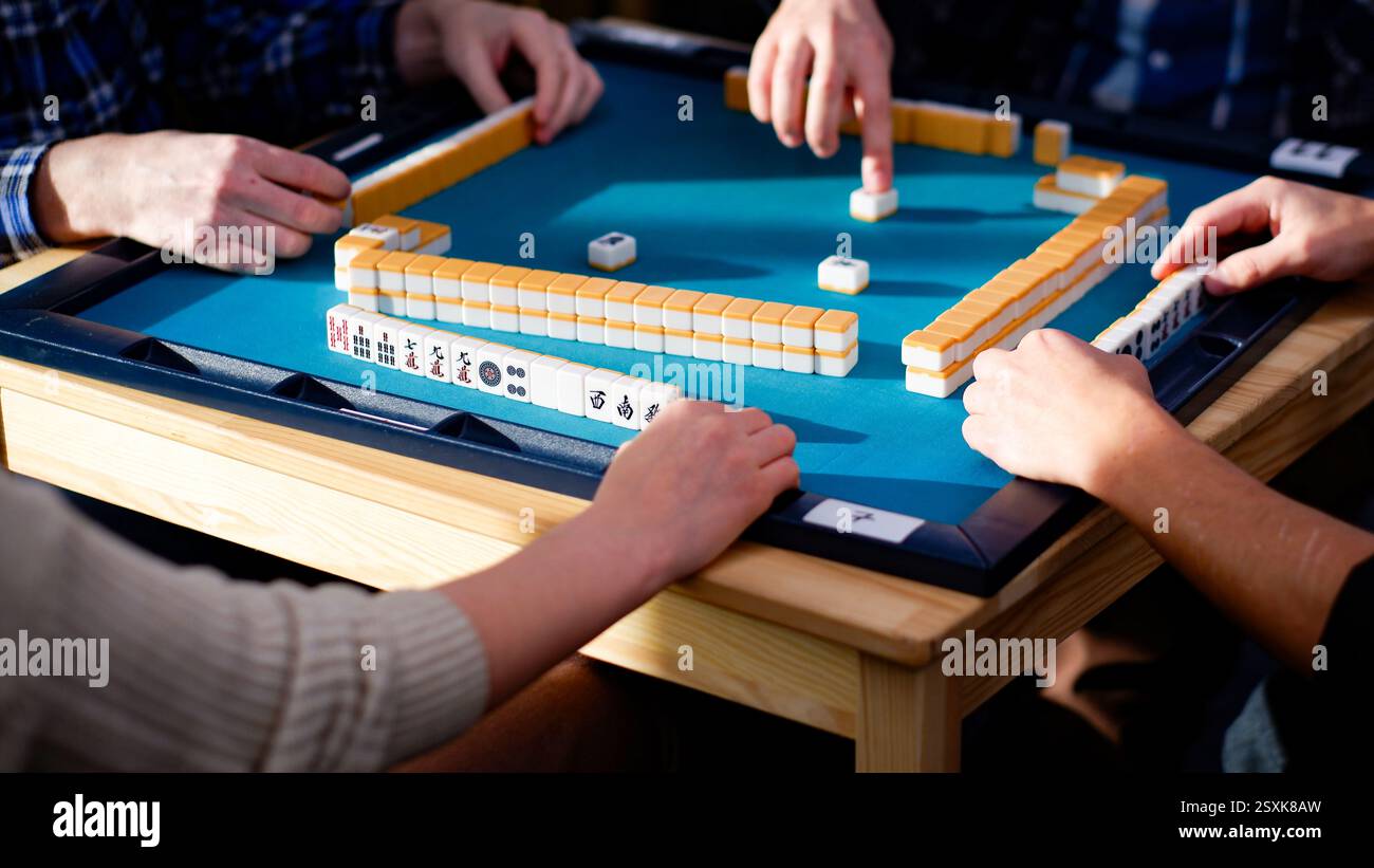 A mahjong table with an active game and the hands of a participant in ...