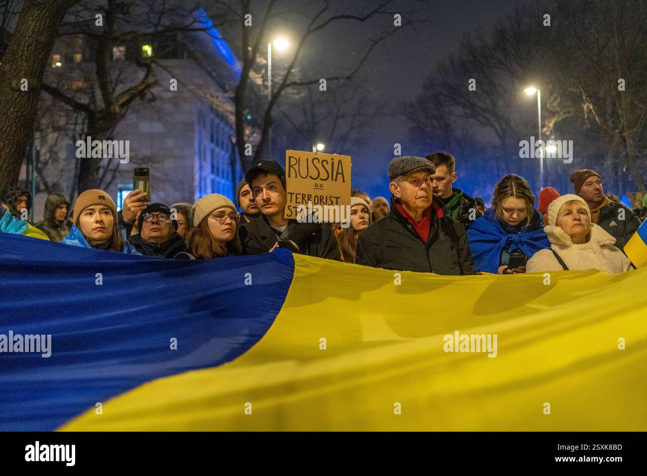 Warsaw, Poland. 24th Feb, 2025. Protesters shouting slogans hold a huge ...