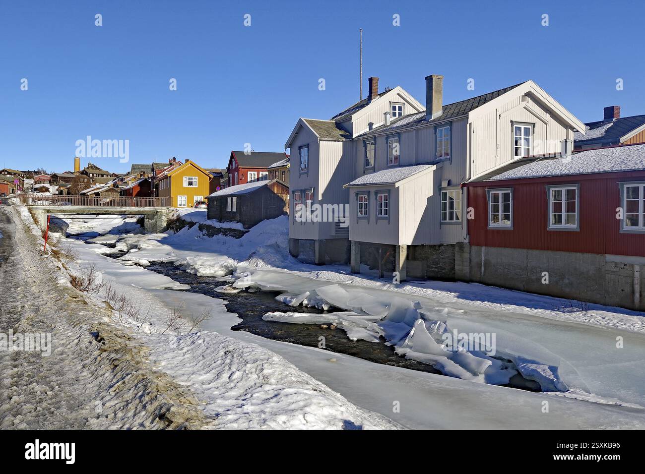 Snow-covered village scenery with colourful wooden houses along a ...
