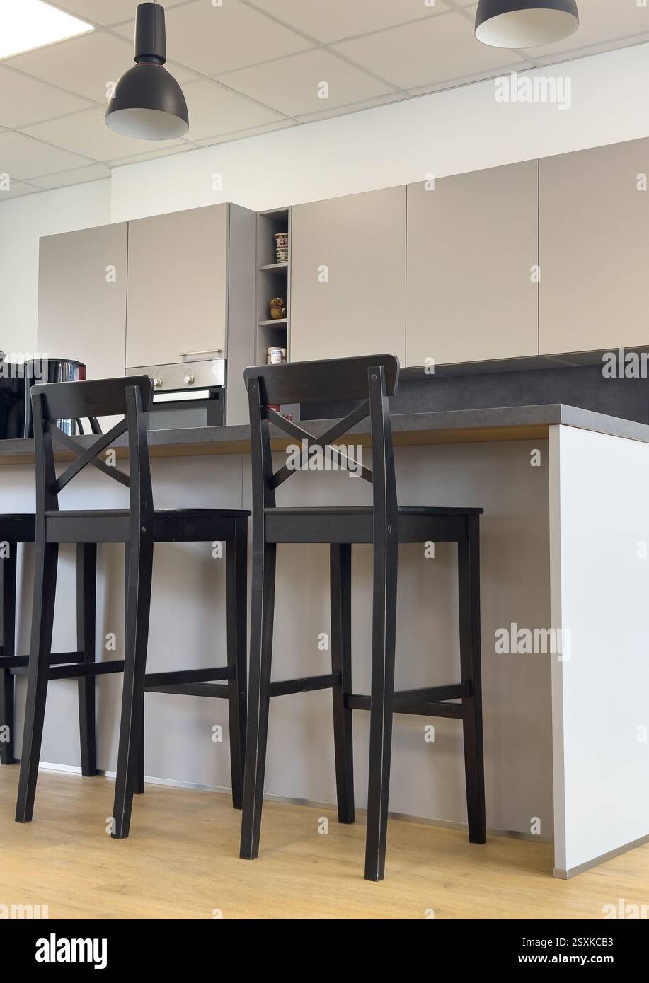 Side view of three tall black wooden bar stools near kitchen island ...