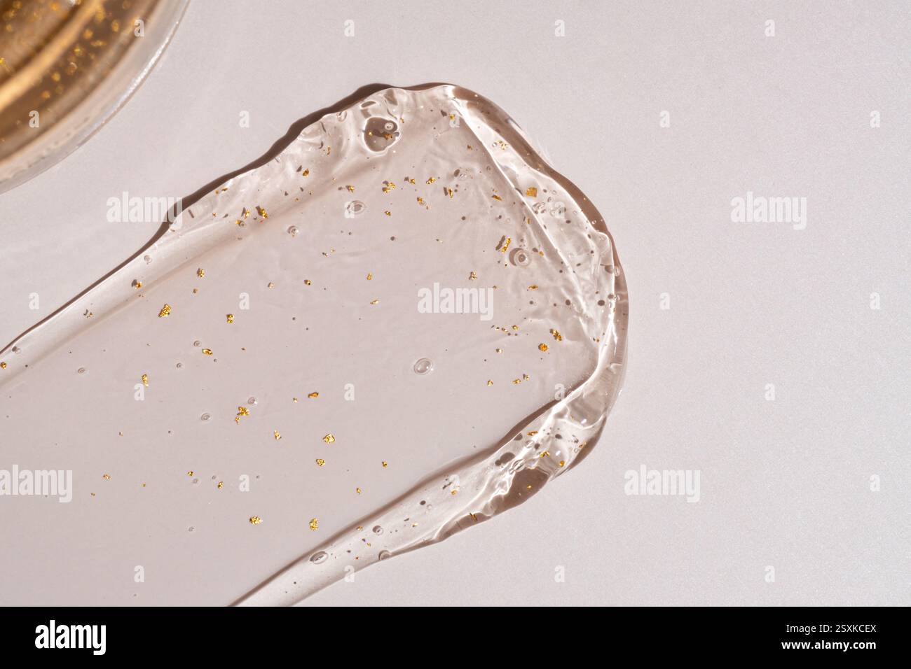 Squeezed cosmetic clear cream gel texture with golden particles ...