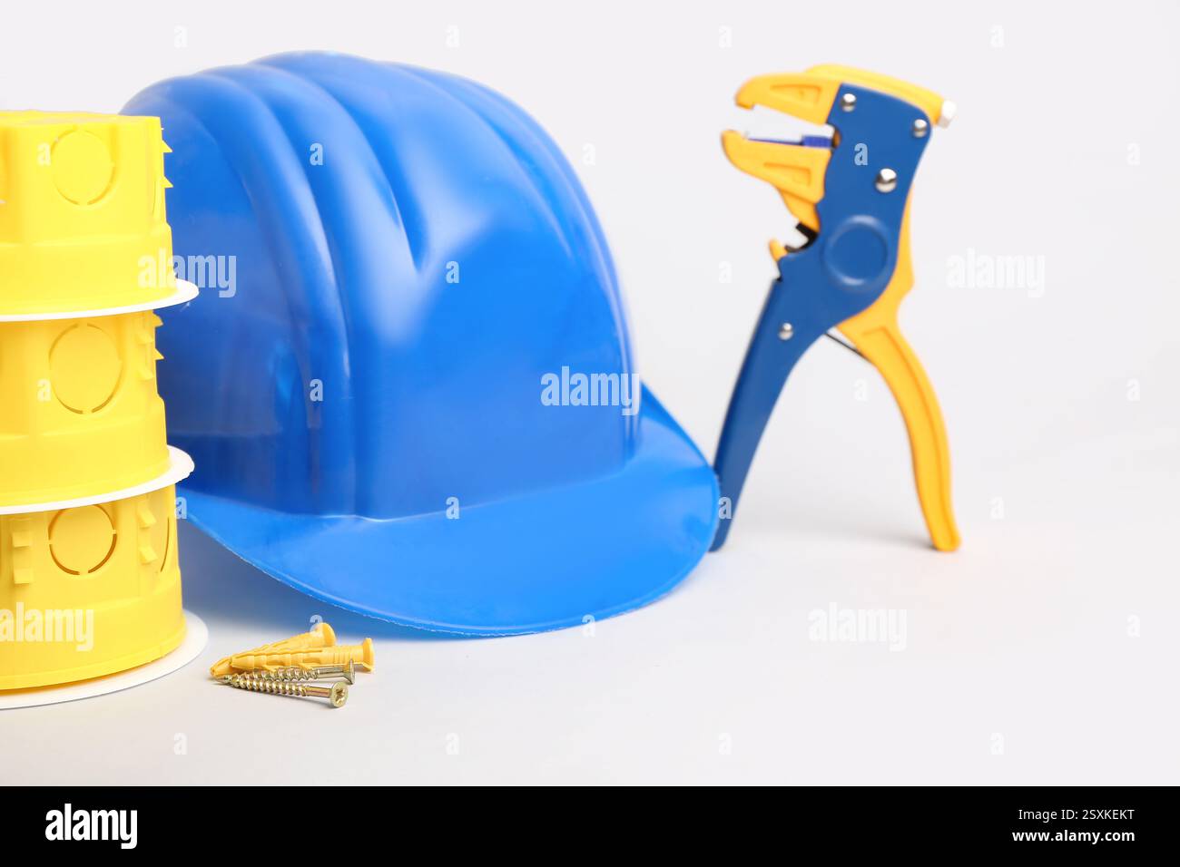 Hardhat, wire stripper, mounting boxes and screws on light background ...