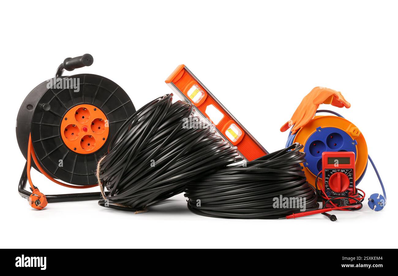 Rolled wires, extension cable reels, multimeter and spirit level on ...