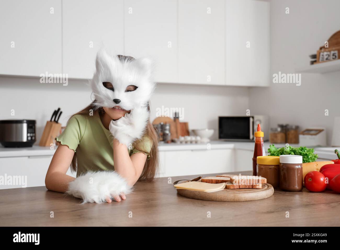 Quadrober girl in cat disguise in kitchen Stock Photo - Alamy