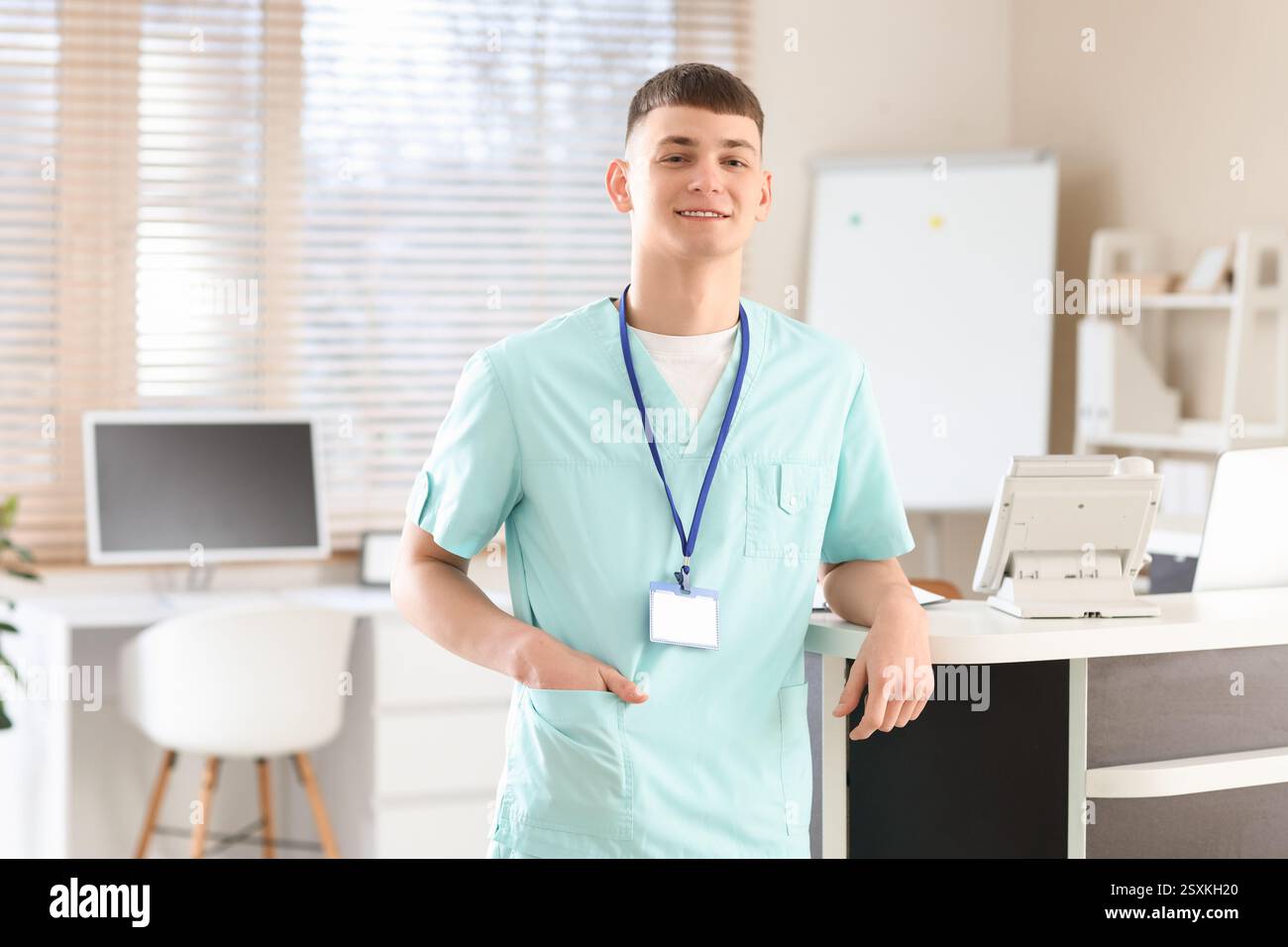 Male medical intern near reception desk in clinic Stock Photo - Alamy