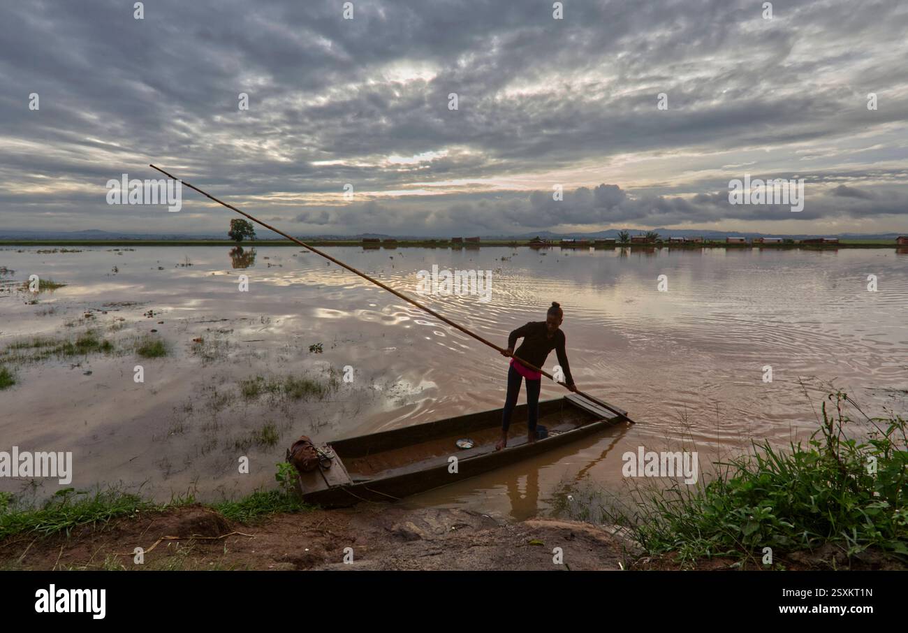 Flooding hits Madagascar A woman crosses the flooded canal and ...