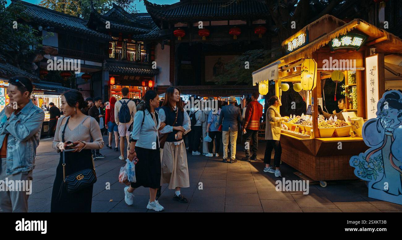Chengdu, Sichuan, China. Two Girls Looking At Cam. People Walk Along ...