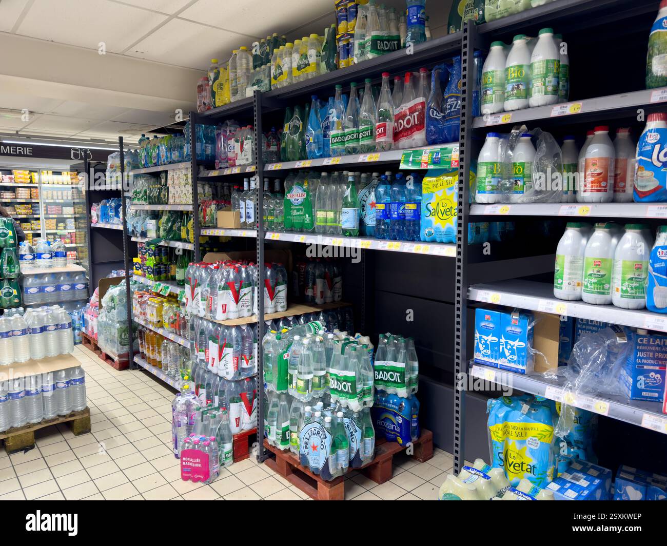 Bottled water aisle filled with various brands in a bustling ...