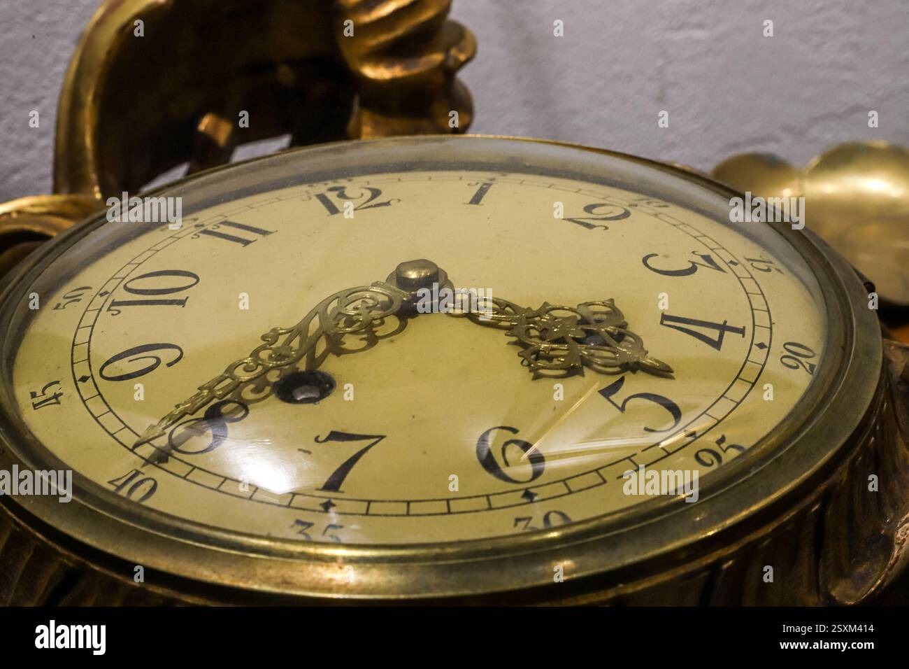 A close-up view of an antique clock highlights its ornate features and ...