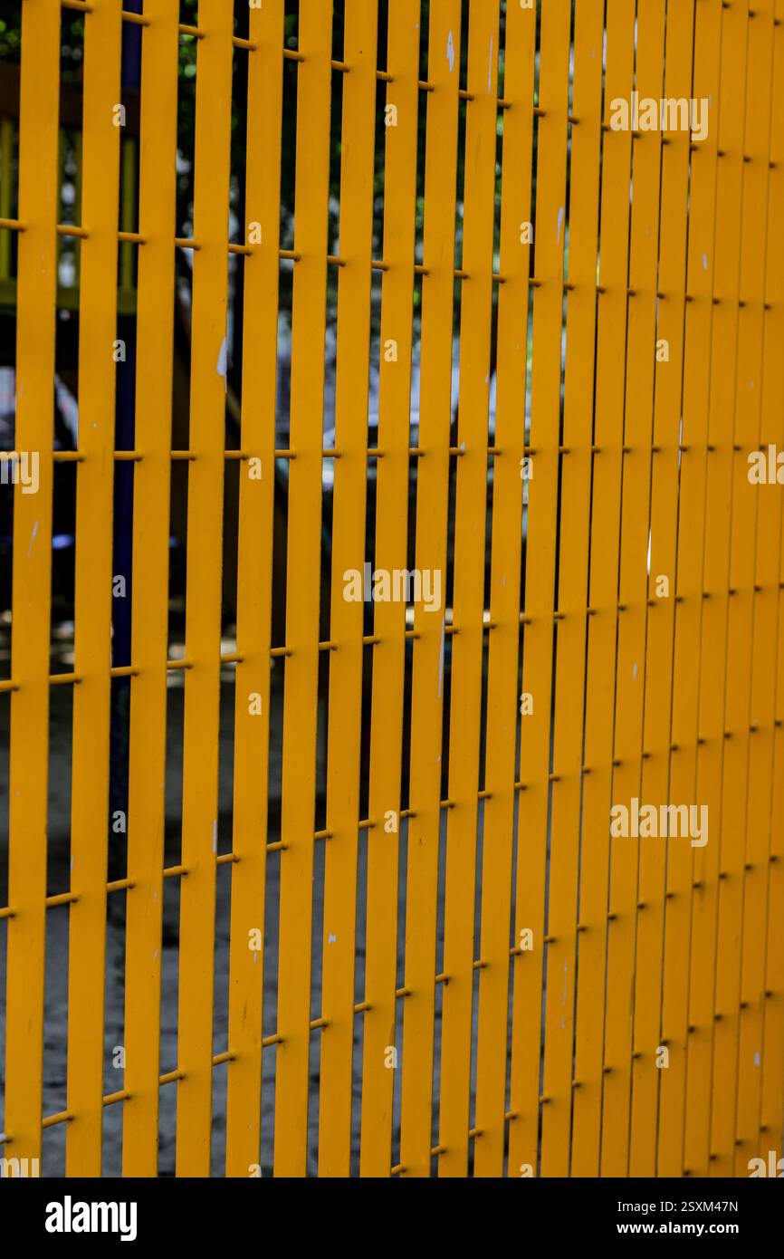A vibrant yellow fence creates a striking visual contrast against a ...