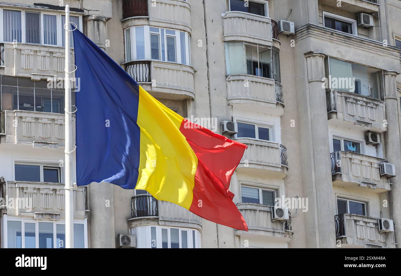 A vibrant Romanian flag flutters in the breeze, prominently displayed ...