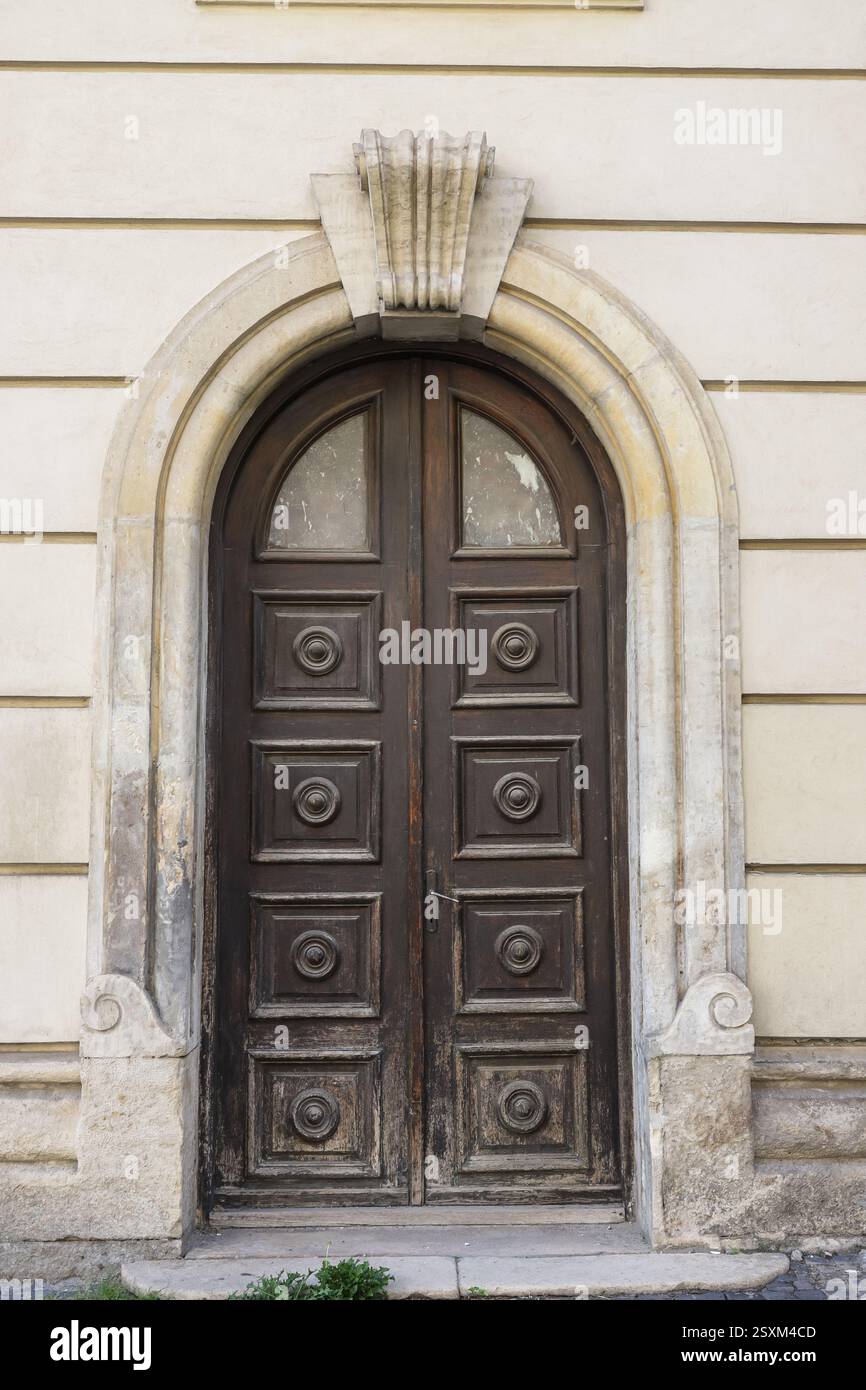 The wooden double door features ornate carvings and a curved arch, set ...