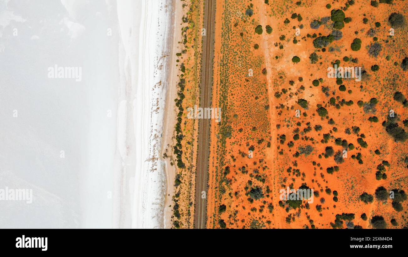 Train tracks divide a saltlake and the desert in the Australian outback ...