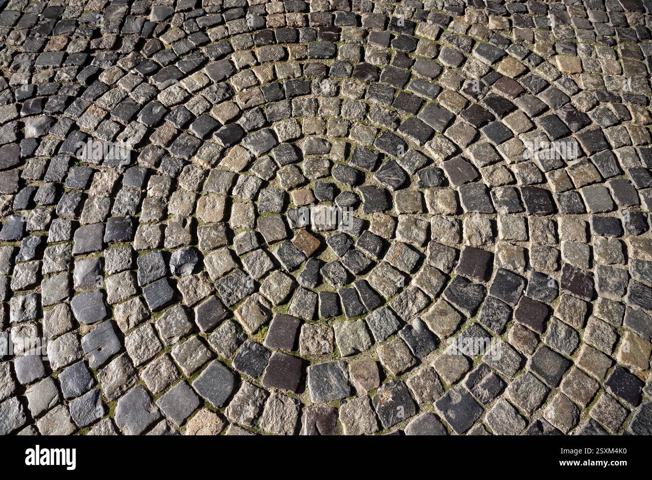 Intricate cobblestone design forms a spiral pattern in a historic town ...
