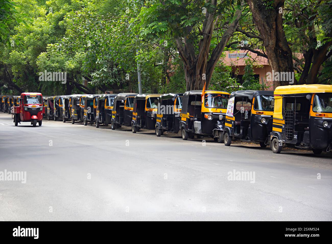 Passenger auto Rickshaws standing in queue on road while Red coloured ...